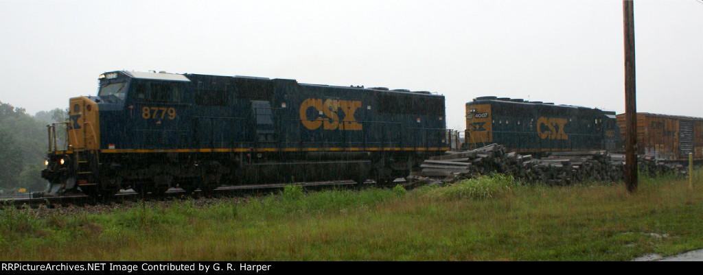 CSXT 8779 and 4007 on Q30327 in pouring rain passing the ever-growing pile of scrapped concrete ...